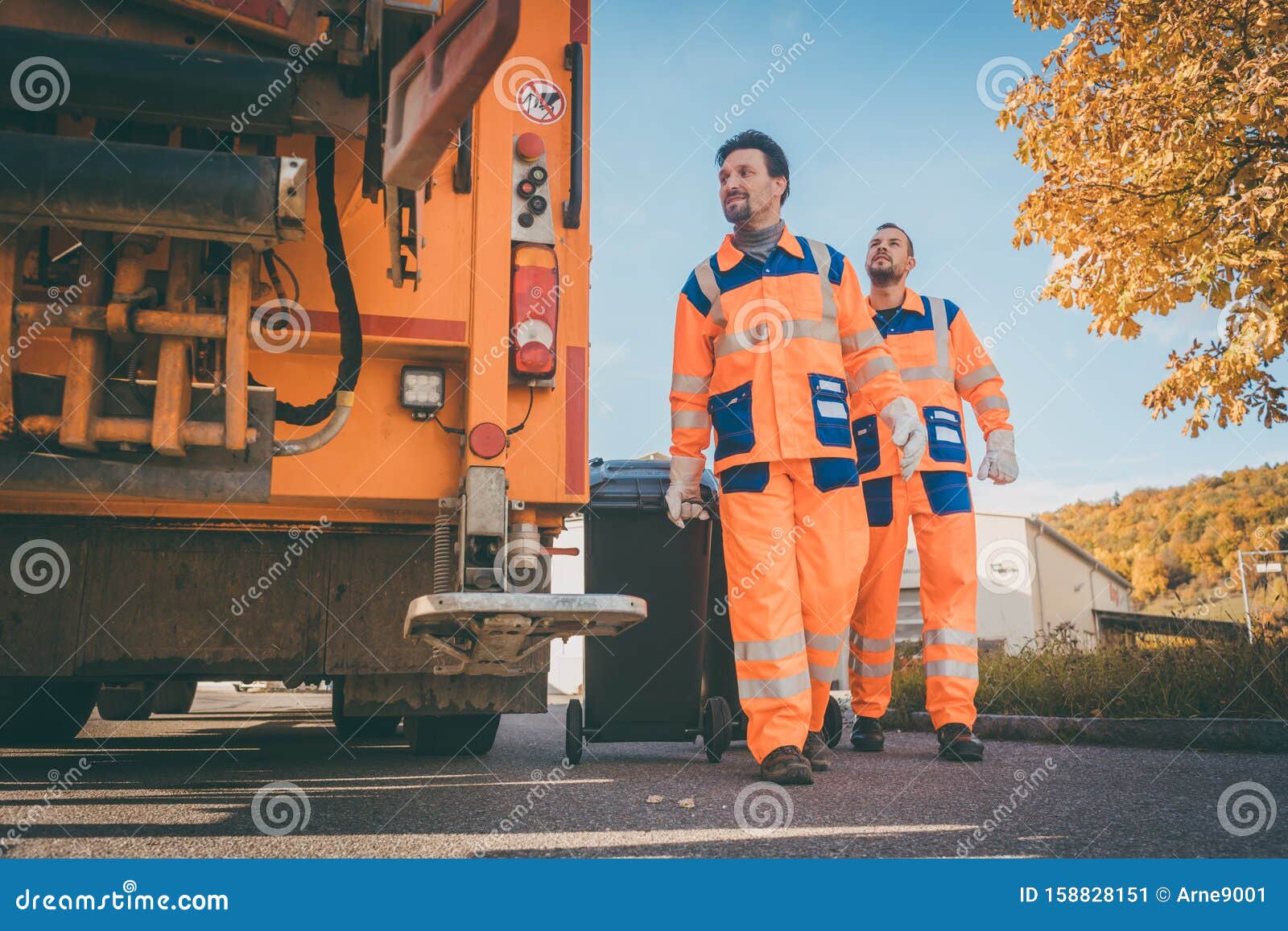 Two Refuse Collection Workers Loading Garbage into Waste Truck Stock ...