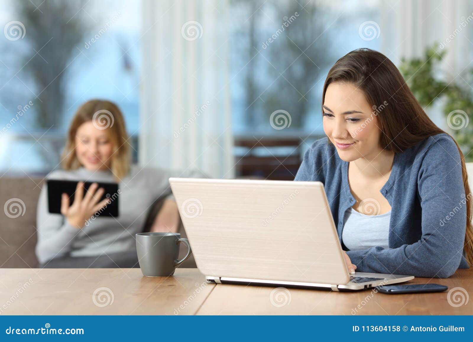Two Relaxed Roommates Using Multiple Devices at Home Stock Photo ...