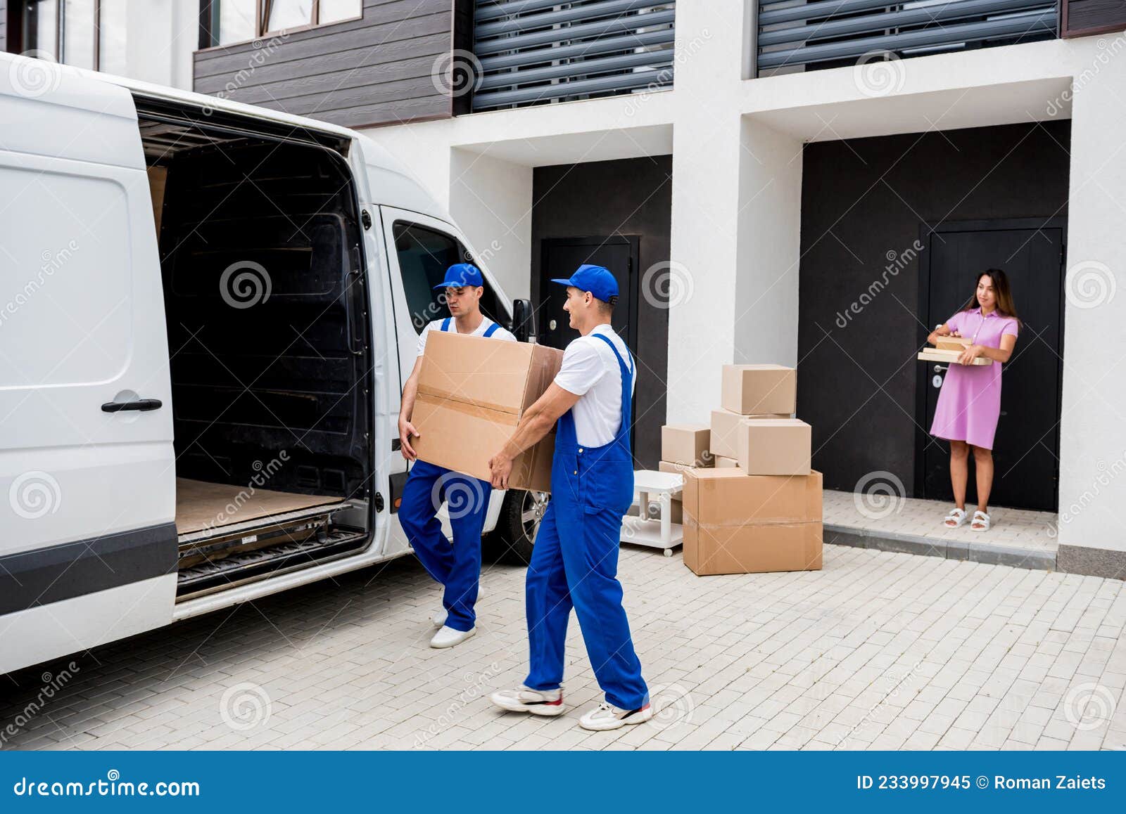 Two Removal Company Workers are Loading Boxes into a Minibus. Stock ...
