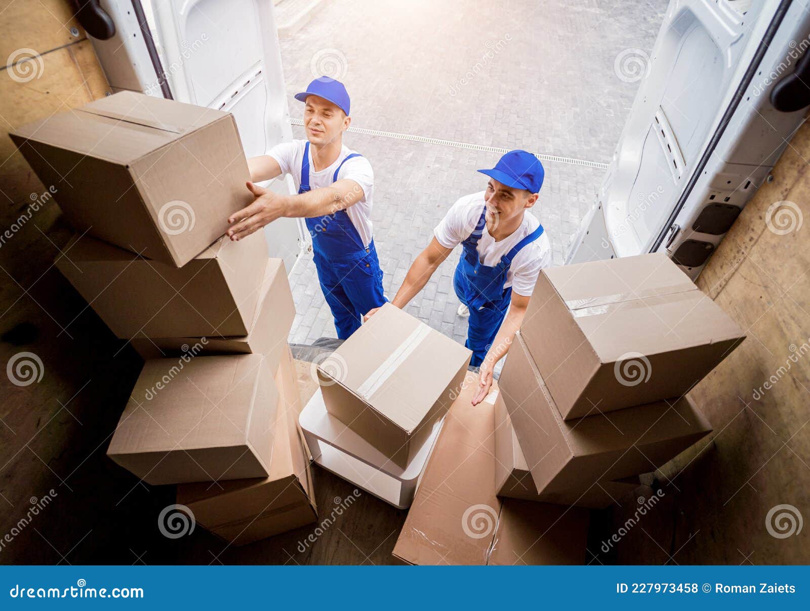 Two Removal Company Workers Unloading Boxes from Minibus Stock Photo ...