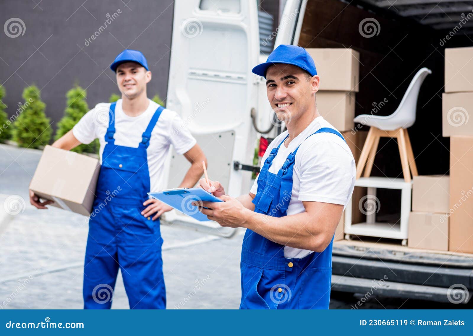 Two Removal Company Workers Unloading Boxes from Minibus into Customer ...