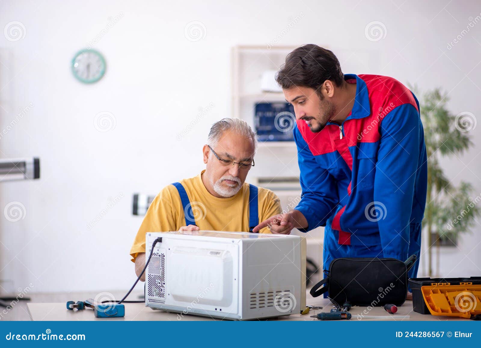 Two Male Repairmen Working at Workshop Stock Image - Image of ...
