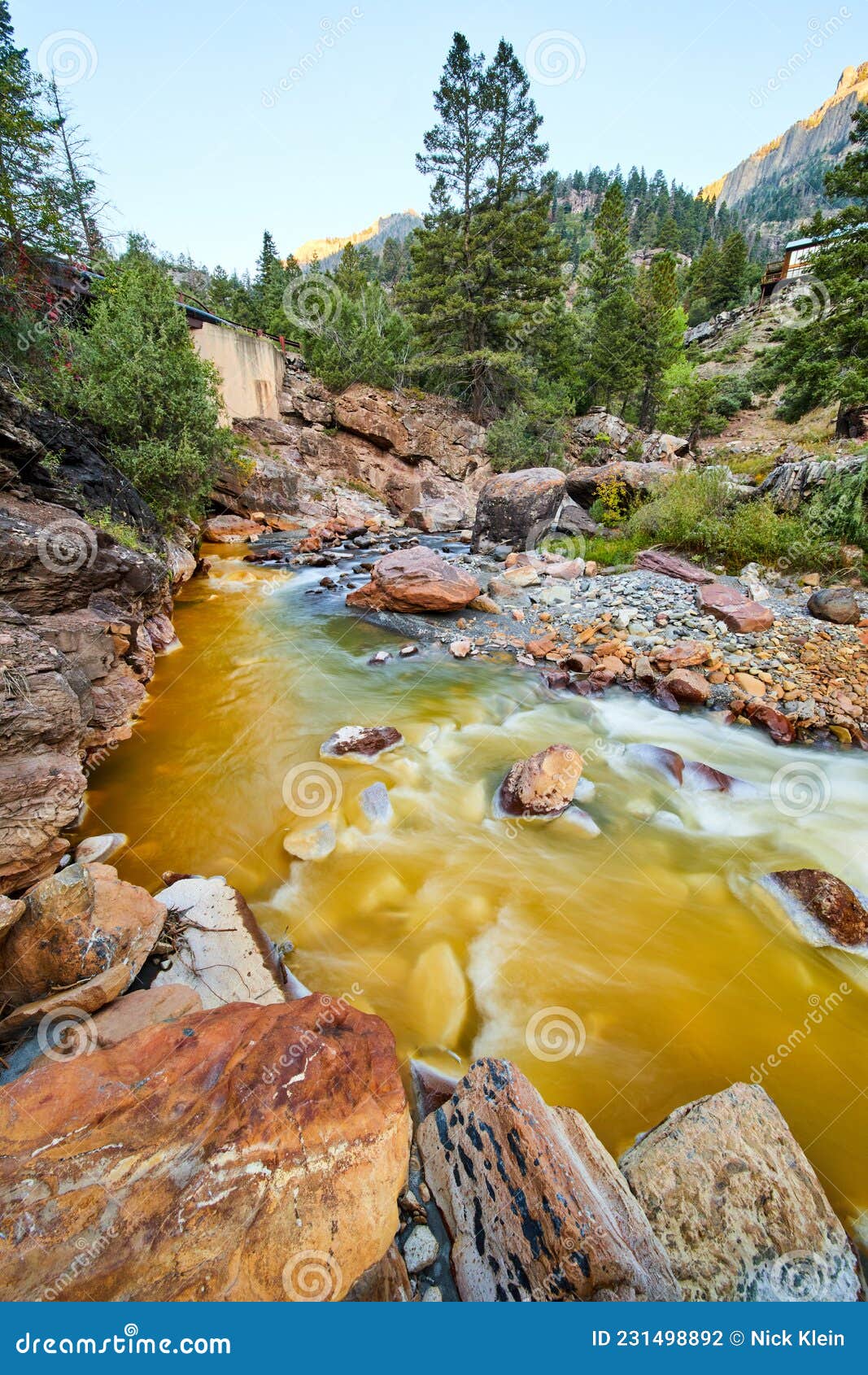 Two Rivers of Clear and Brown Water Merging at Bend in Rocks with ...