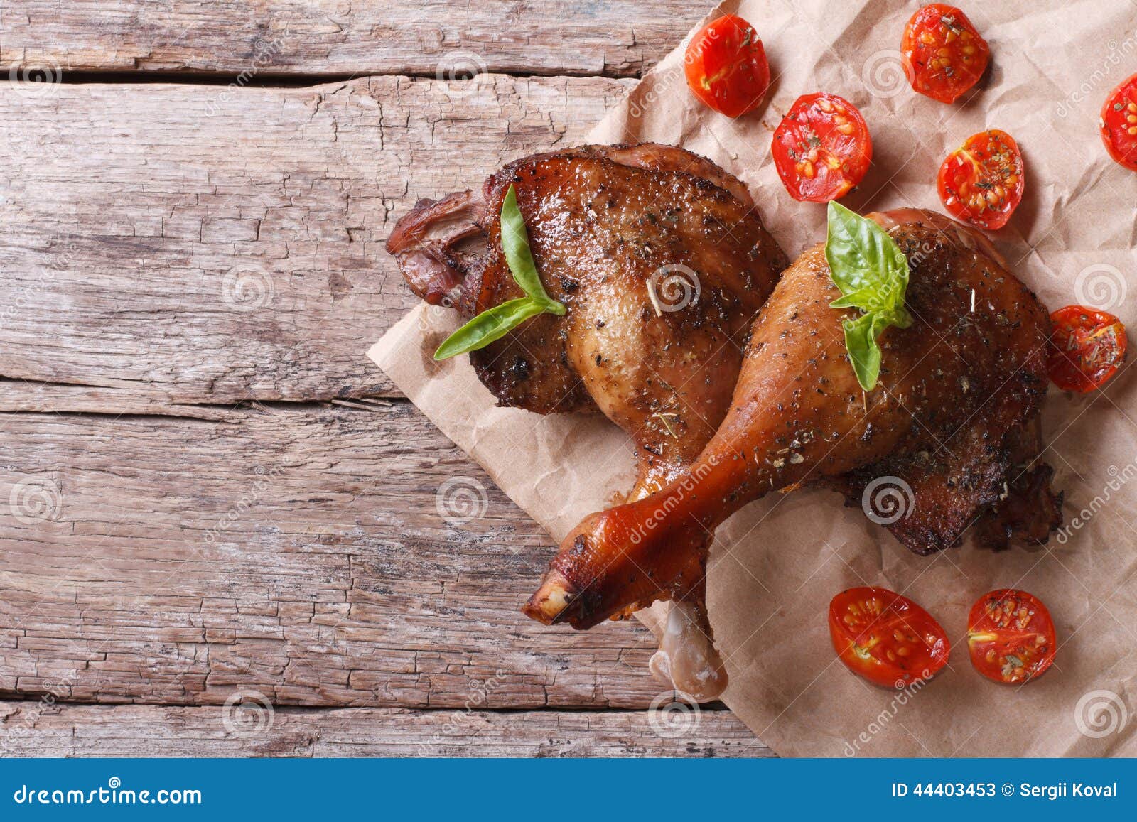 Two Roasted Duck Legs with Basil and Tomatoes Closeup an Table Stock ...