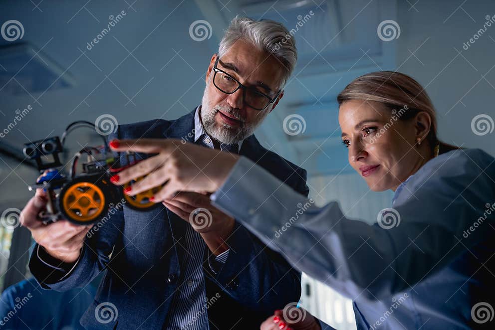 Two Robotics Engineers Assembling Robotic Car. Concept of Modern ...