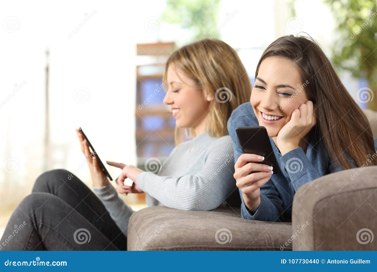 Two Roommates Using Multiple Devices at Home Stock Photo - Image of ...
