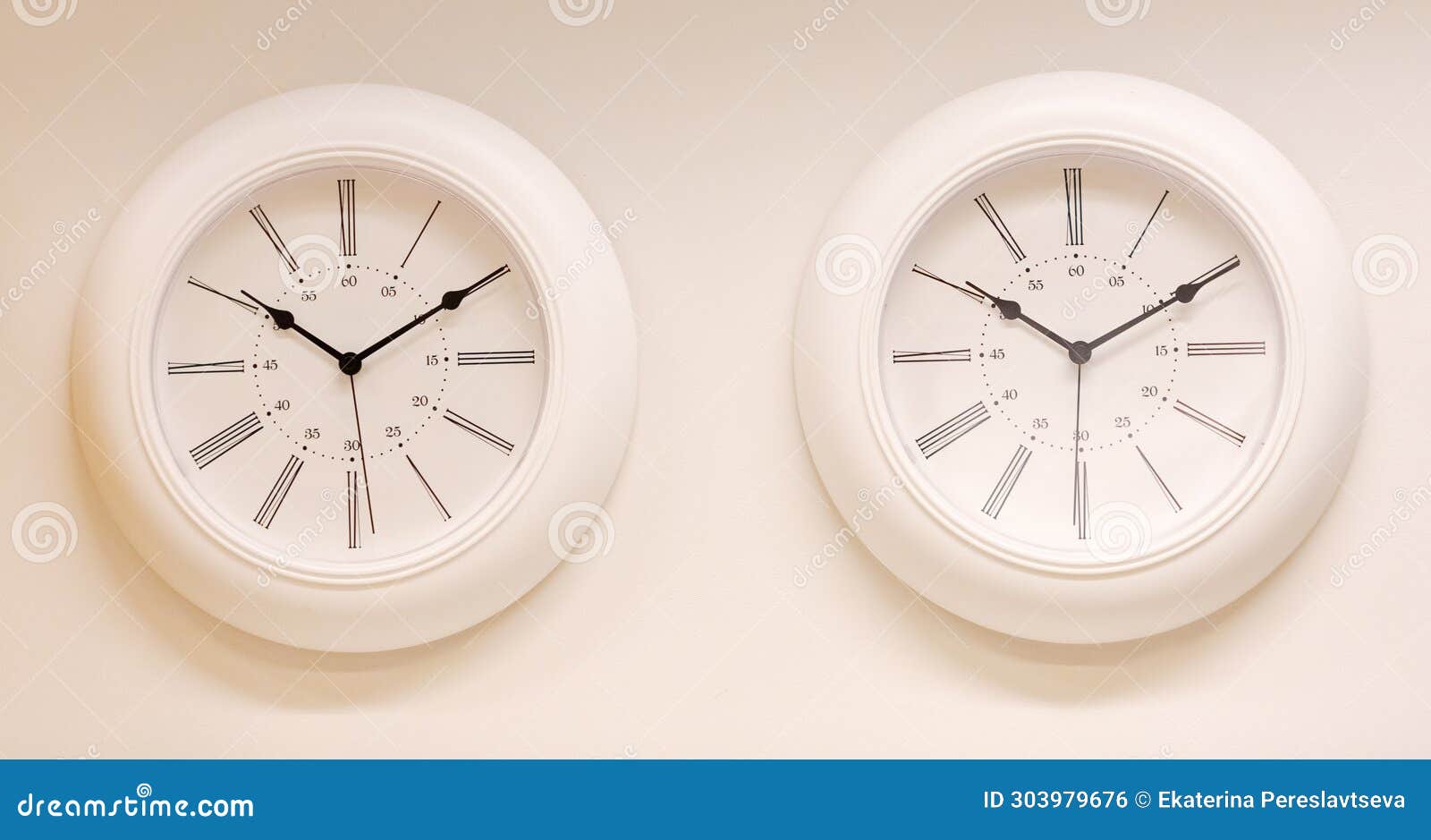 Two Round Wall Clocks on a Light Wall Show the Same Time. Stock Photo ...