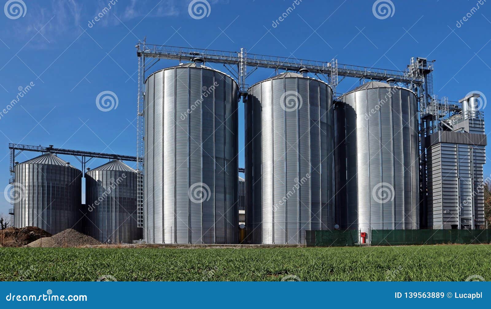 Two Rows of Grain Silos Bright Under the Spring Sun Stock Image - Image ...