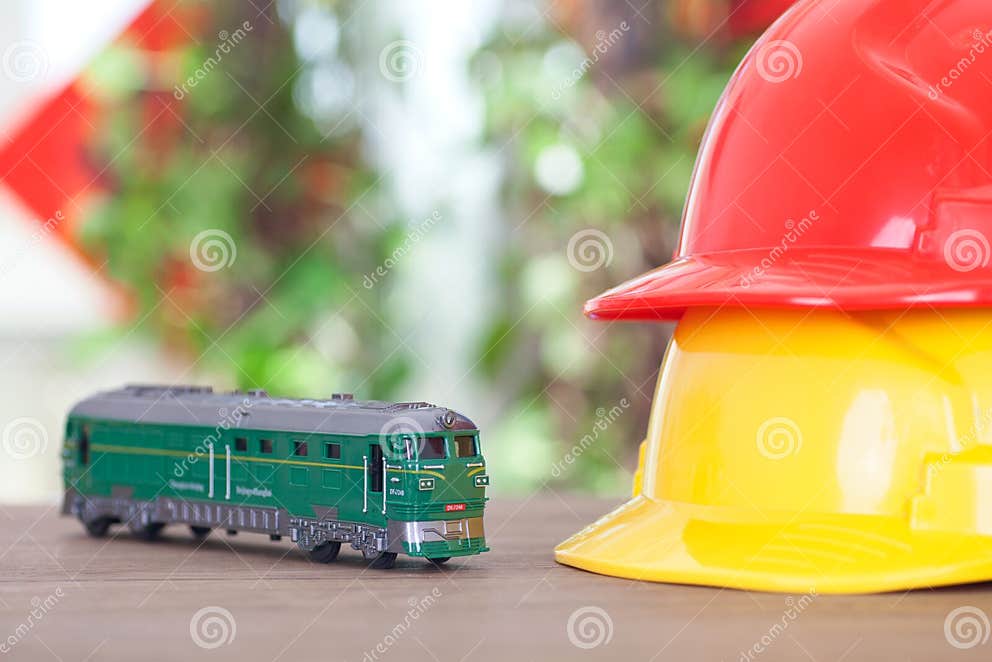 Two Safety Helmets and a Model Green Train on the Table Stock Photo ...