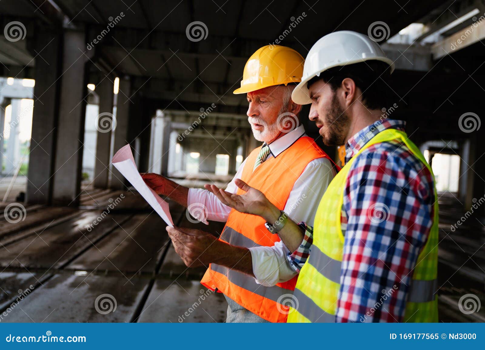 Two Satisfied Engineers Talking at Building Site with Construction ...