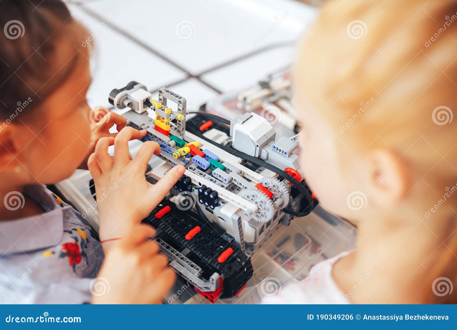 Two Schoolgirls Study in a Robotics Class, Assemble a Robot Constructor ...