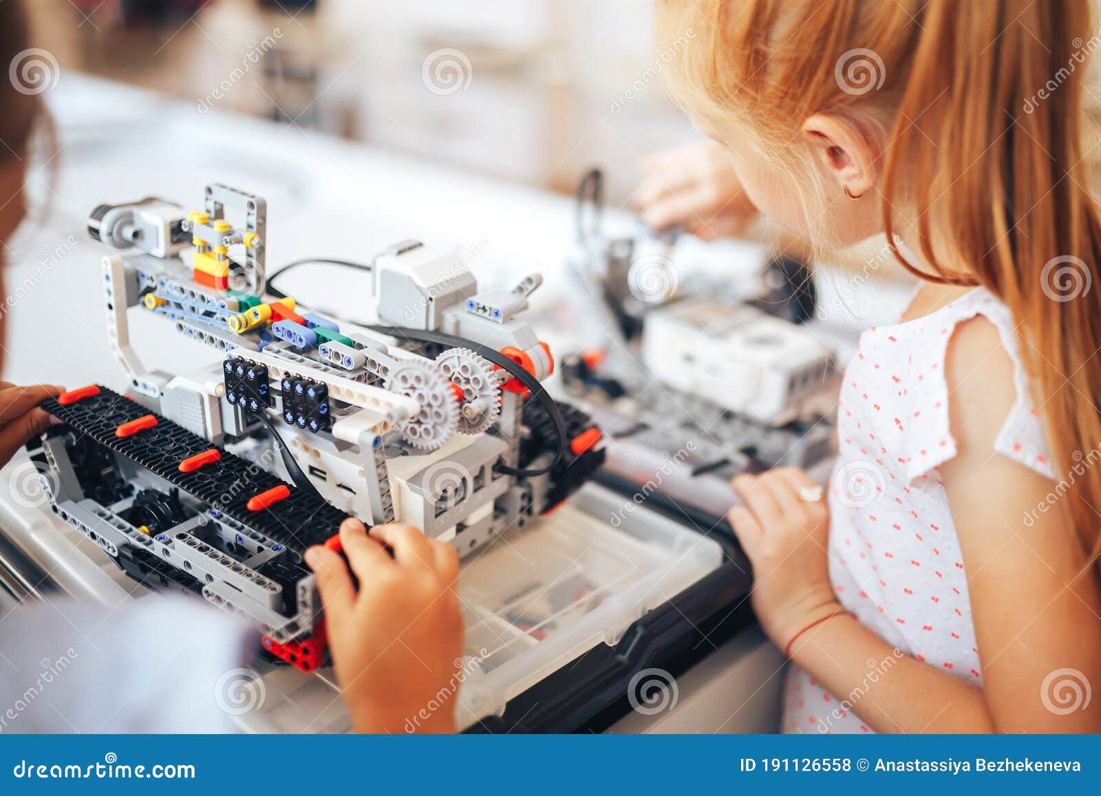 Two Schoolgirls Study in a Robotics Class, Assemble a Robot Constructor ...