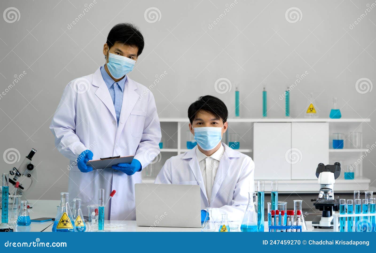 Two Scientists with Face Mask and Gown Working in Laboratory. Omicron ...