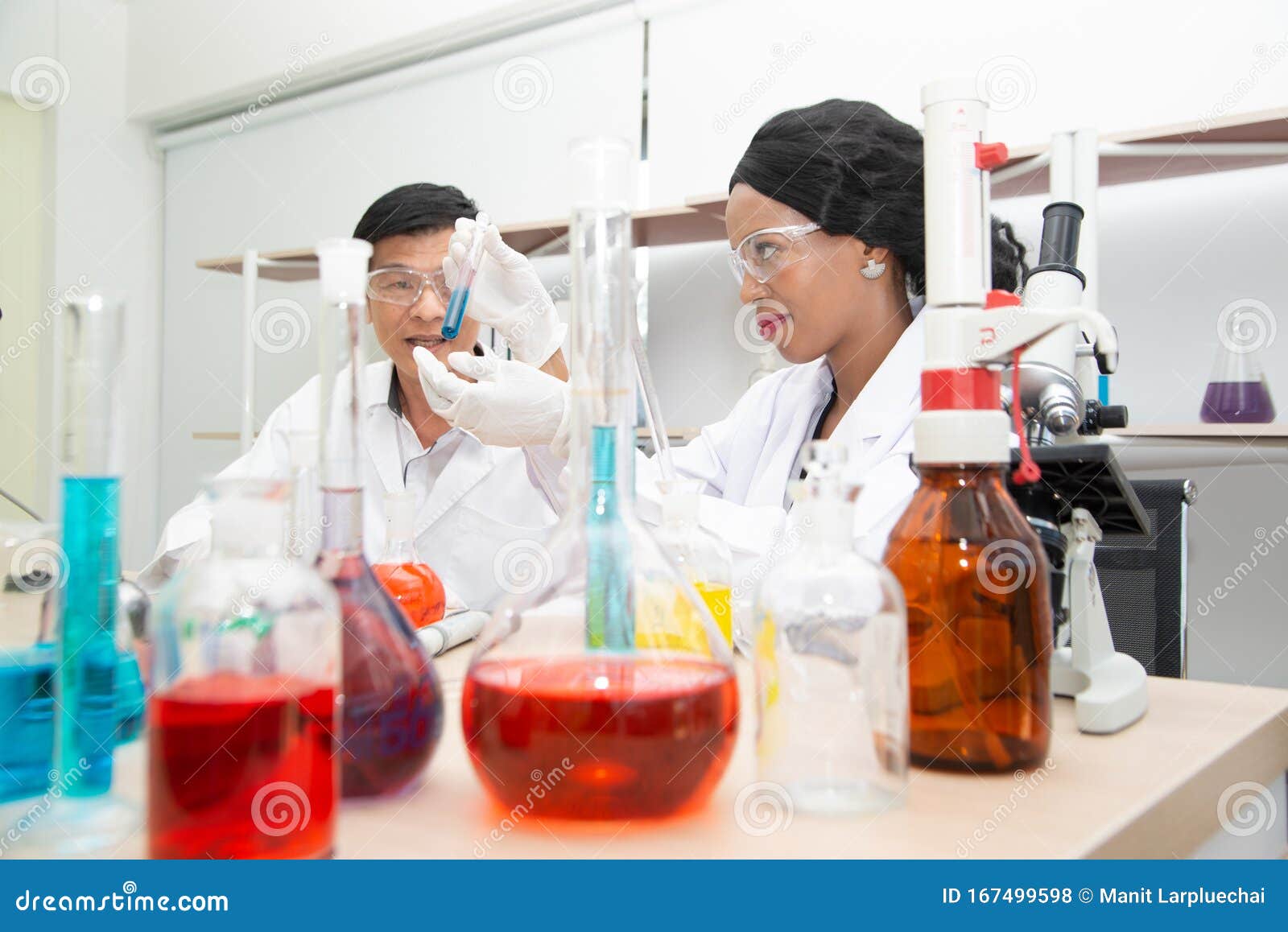 Two Scientists are Working in Laboratory.Young Female Researcher and ... Two Scientists are Working in Laboratory.Young Female Researcher and ...