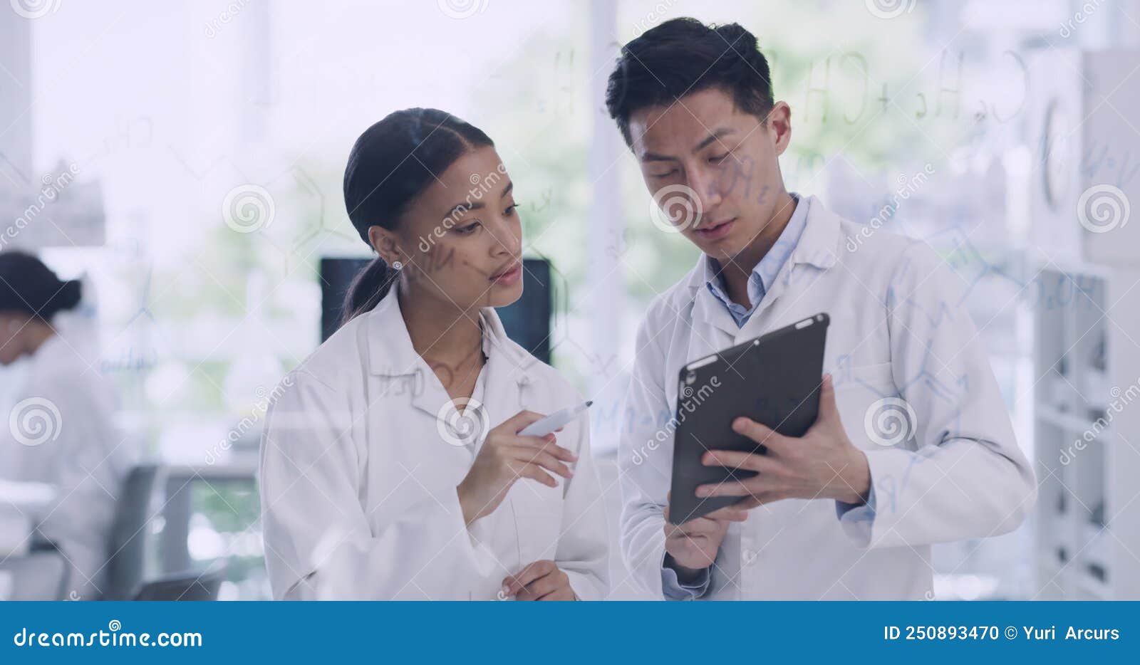 Two Scientists Working Together Using a Tablet Inside a Modern Lab ...