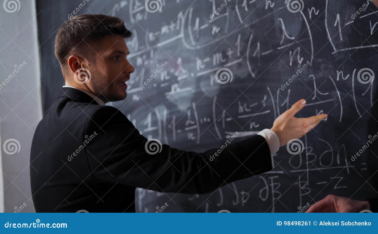 Two Scientists Writing, Discussing Math Equations and Formulas on a ...