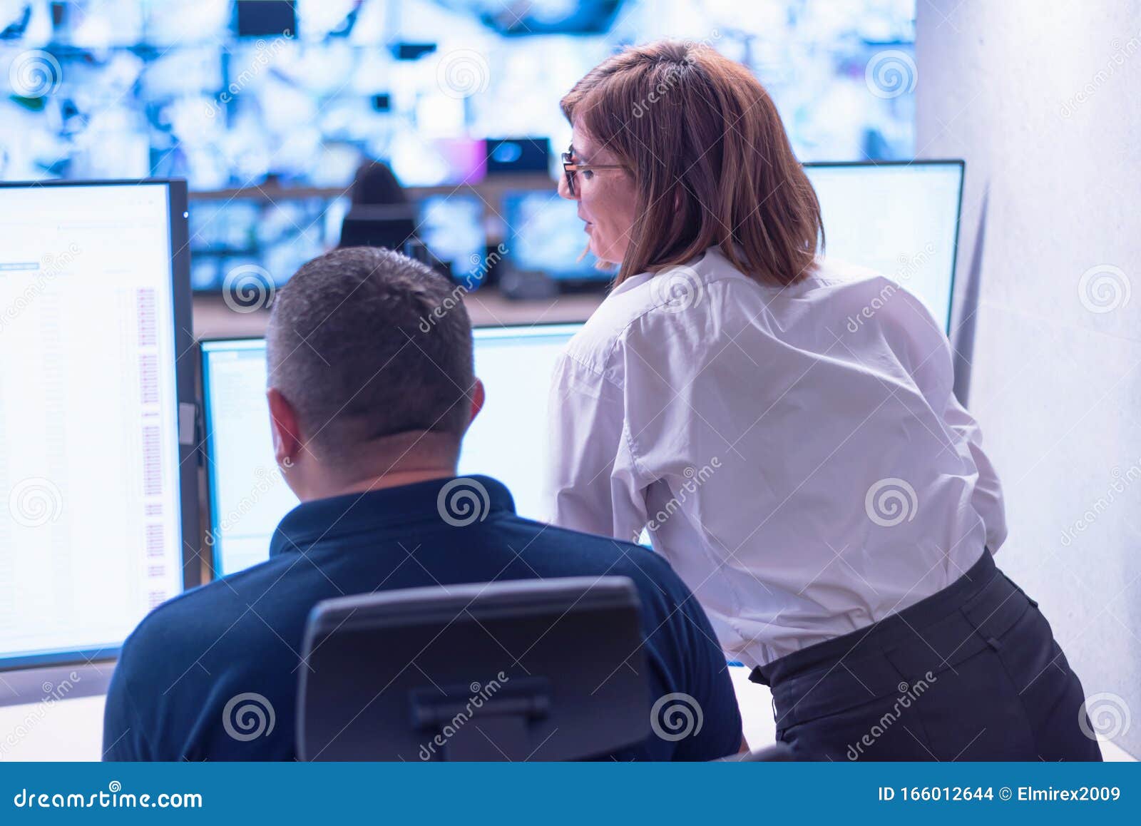 Two Security Guards Working on Computers while Sitting in the Main ...