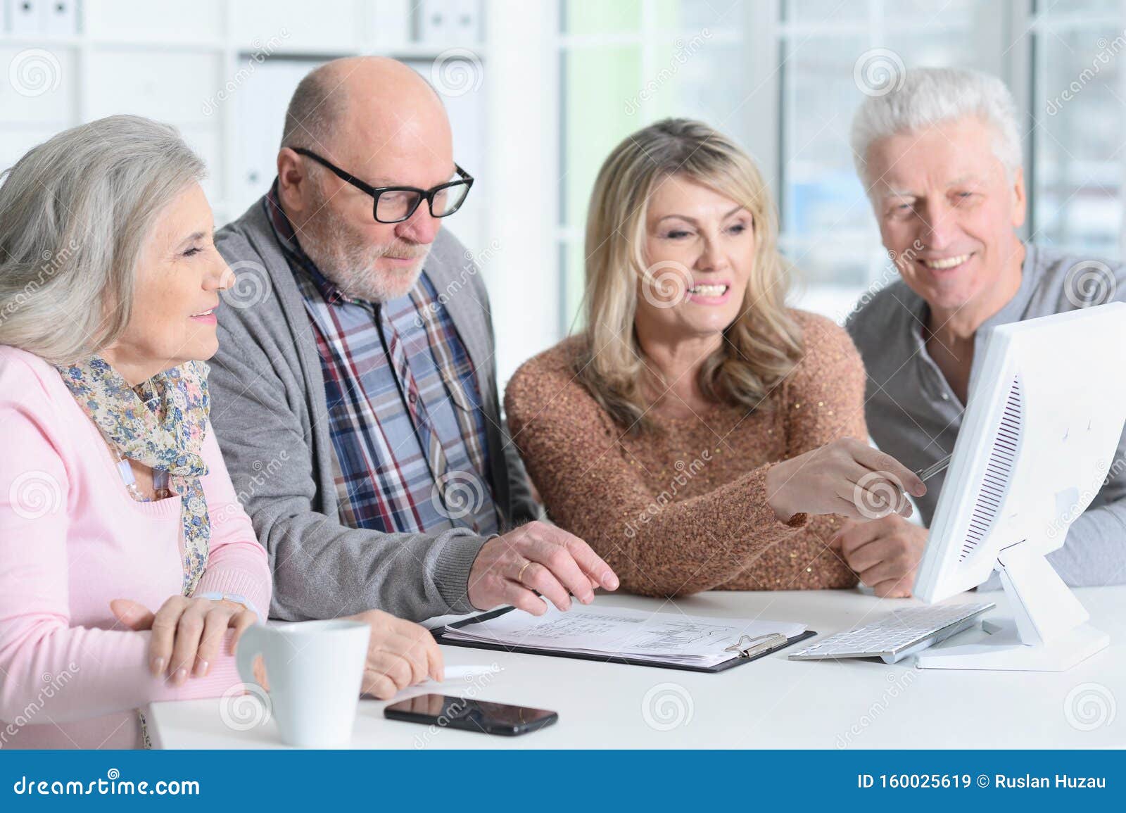 Portrait of Two Senior Couples Sitting at Table and Working Stock Image ...
