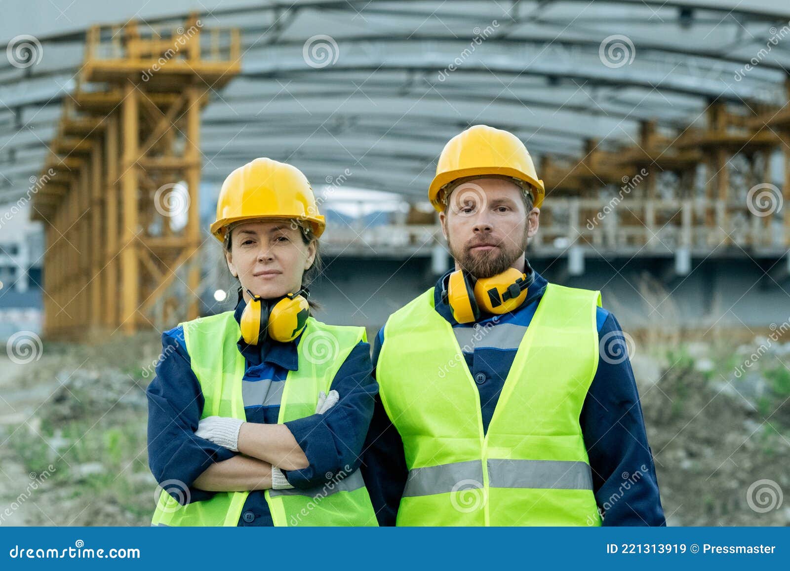 Two Serious Construction Workers Standing Next To One Another Stock ...