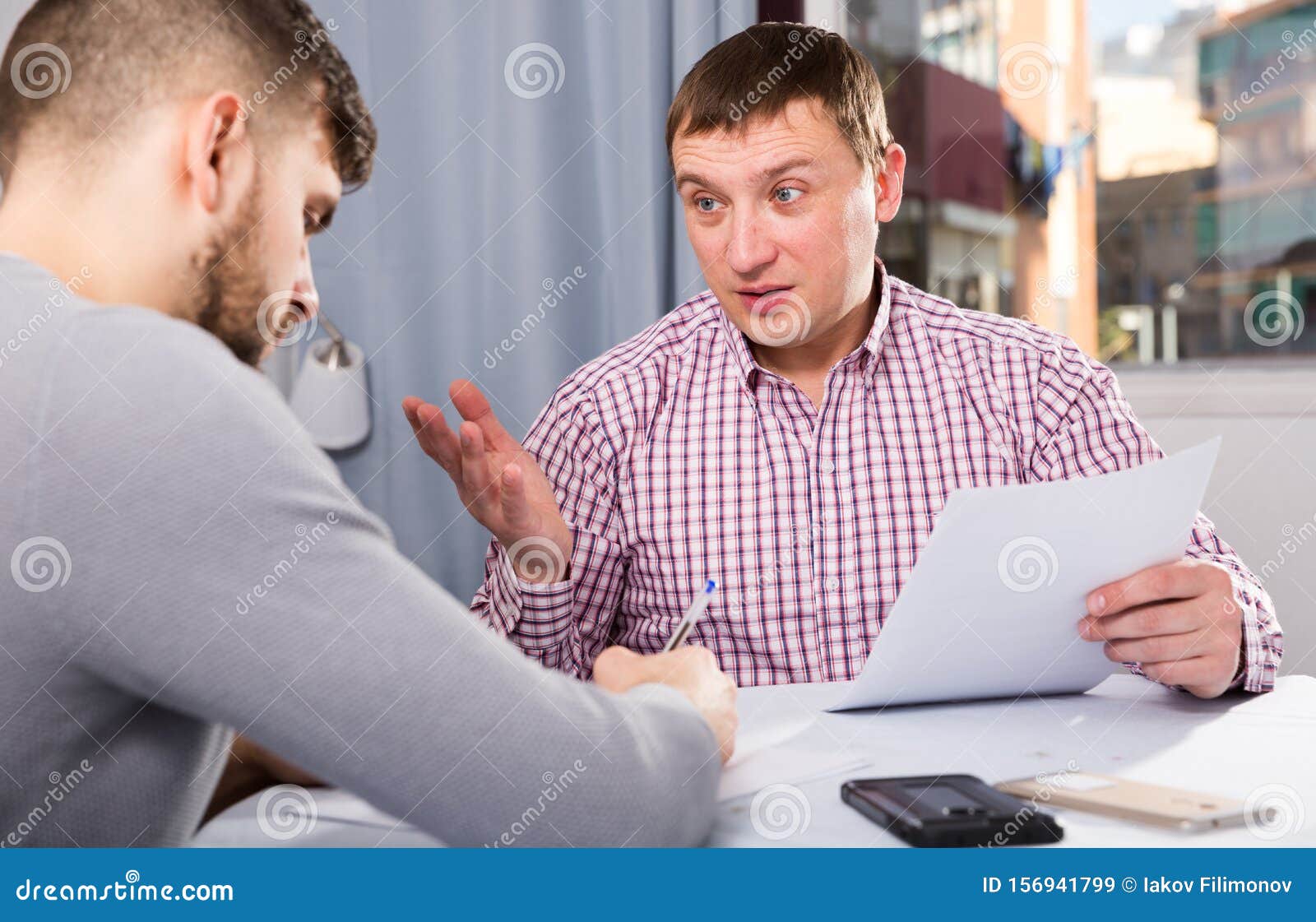 Two Serious Men Analysing Documents at Table Stock Image - Image of ...