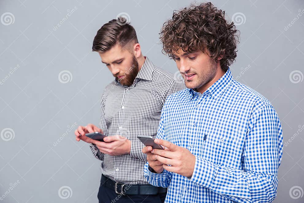 Two Serious Men Using Smartphone Stock Photo - Image of lifestyle ...
