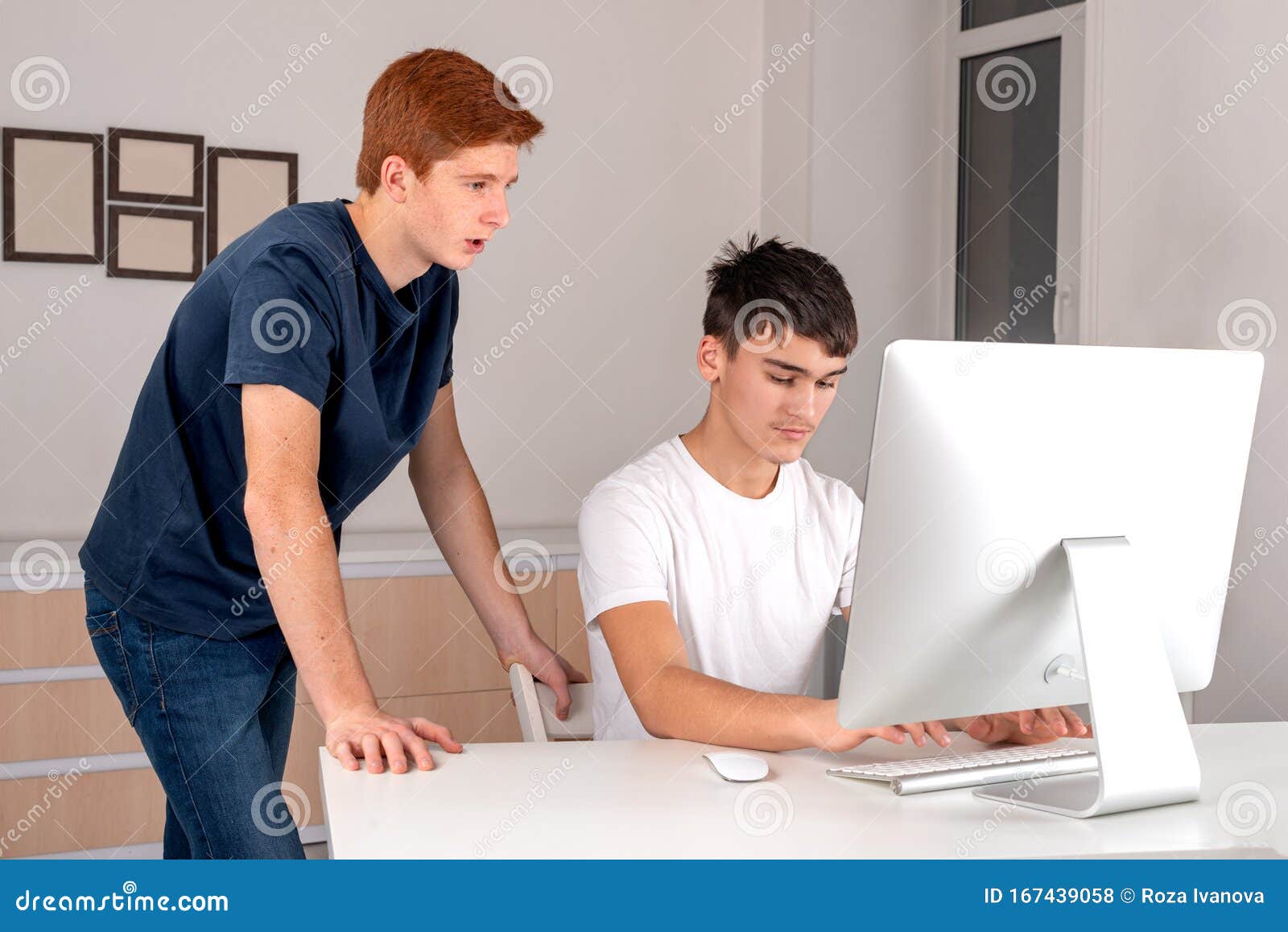 Two Serious Teenager Guys are Using Computer and Discussing Something ...