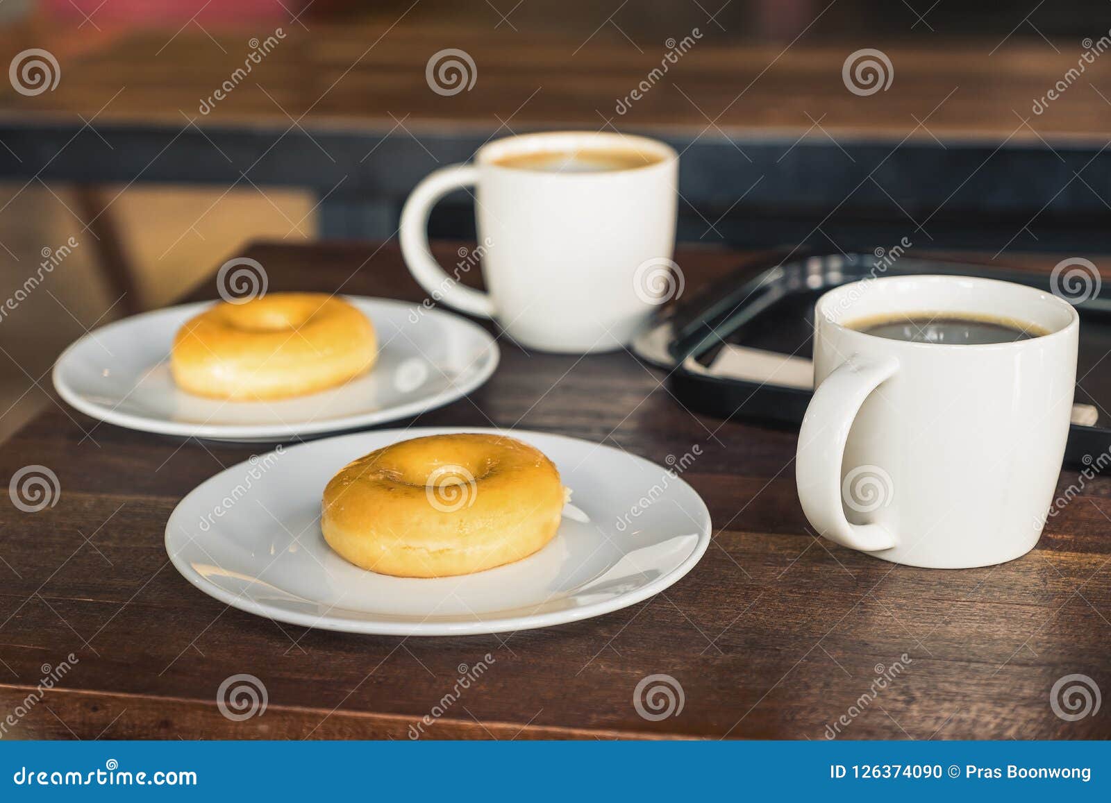 Two Set of Donuts in a White Plate with Coffee Cups on Wood Table Stock ...