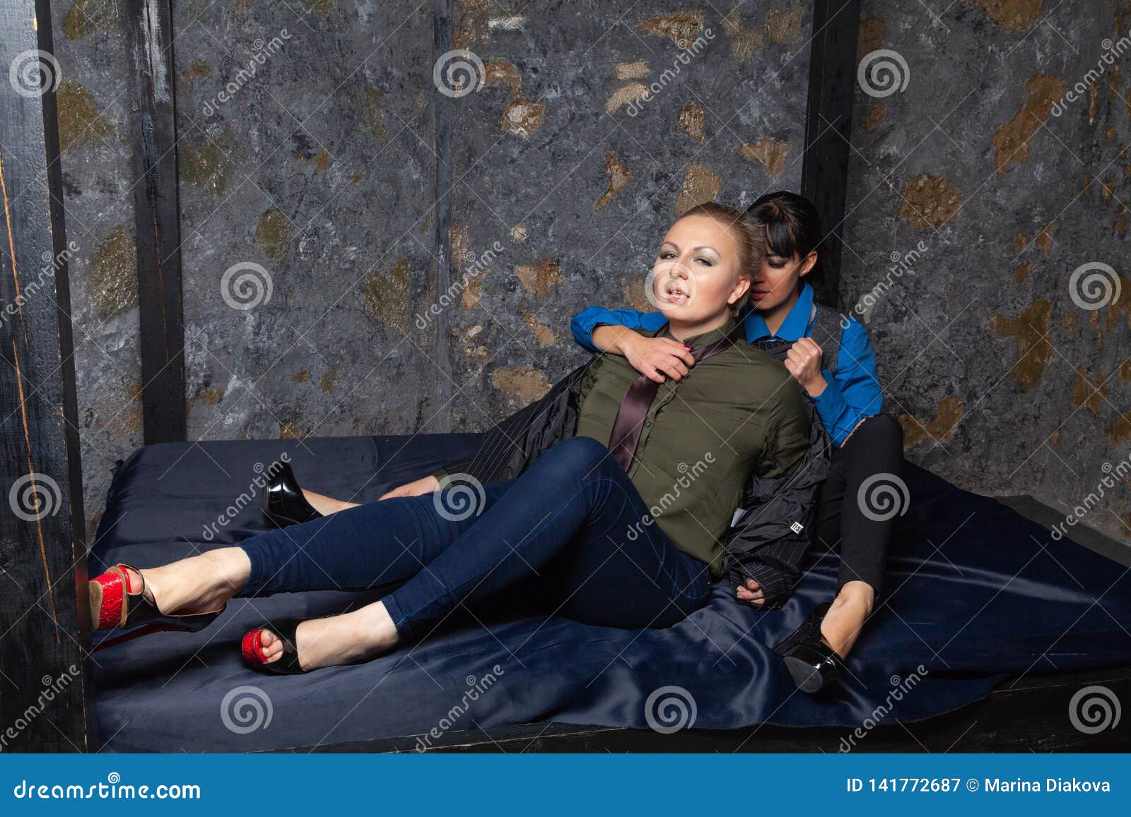Two Lesbian Girls Making Love On A Black Bed In Their Bedroom Stock