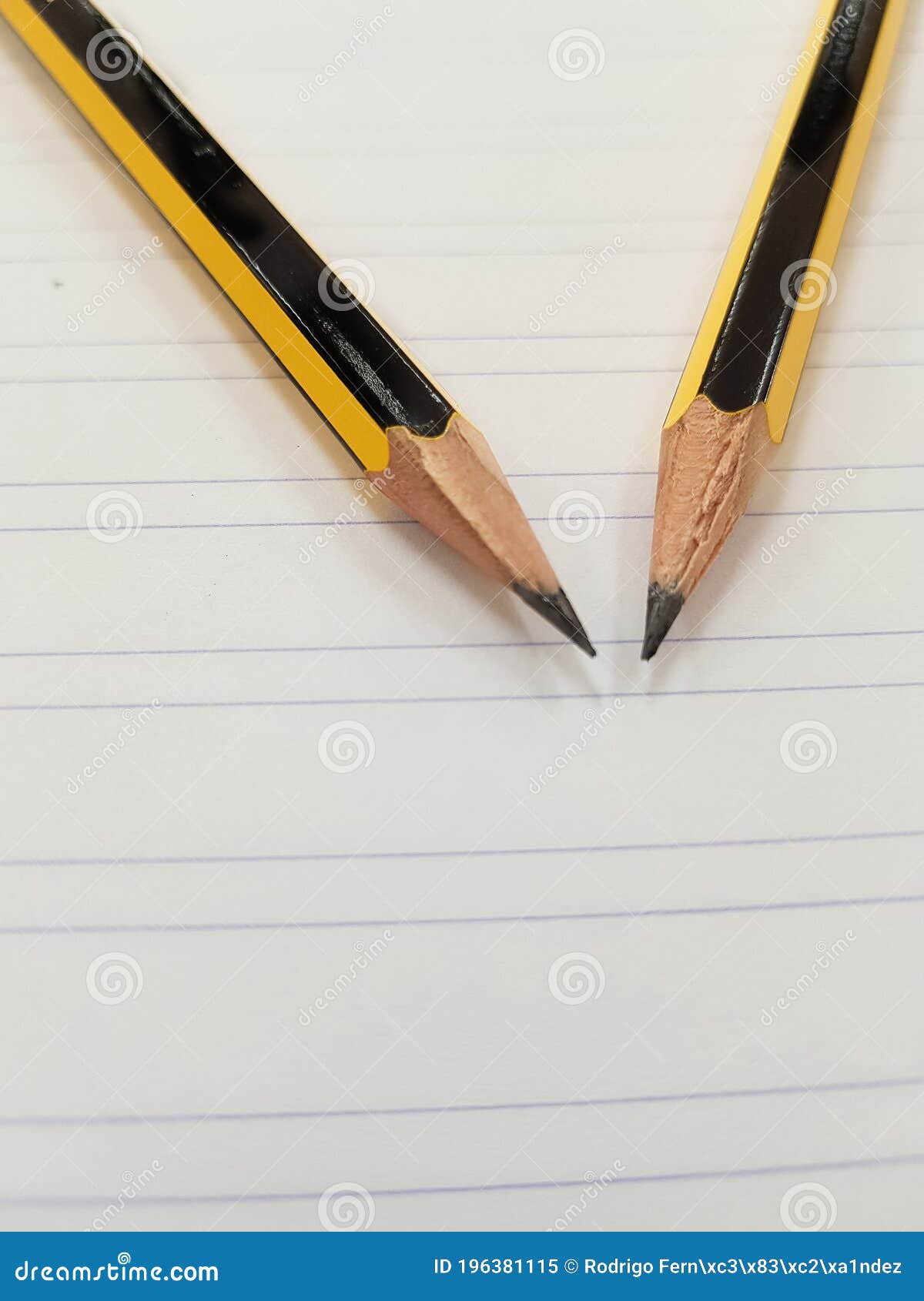 Two Sharpened Pencil Over a Ruled White Paper Stock Image - Image of ...