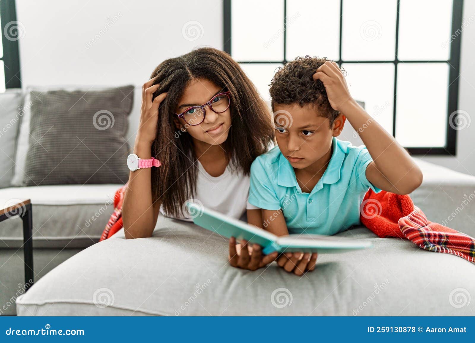 Two Siblings Lying on the Sofa Reading a Book Confuse and Wondering ...