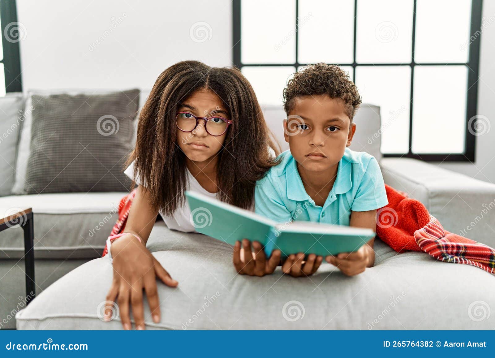 Two Siblings Lying on the Sofa Reading a Book Depressed and Worry for ...