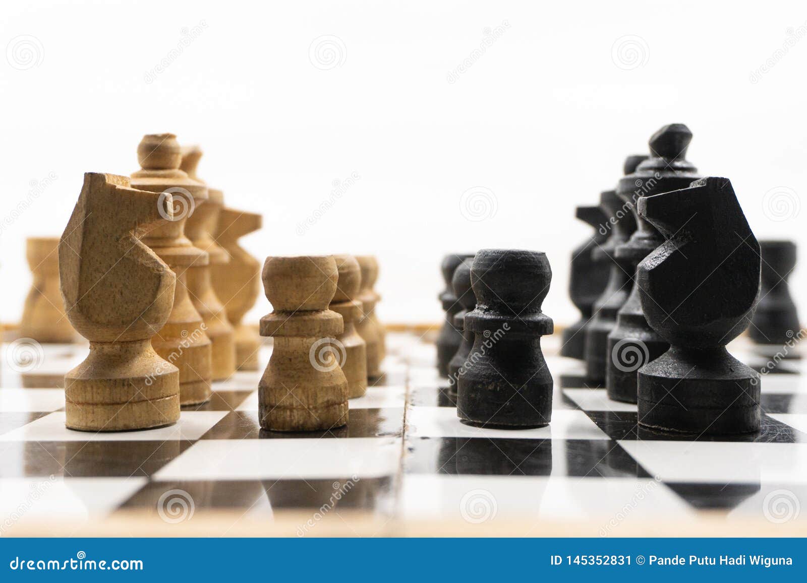 Two Sides of Black and White Chess Pieces, Which are Made of Wood, are ...