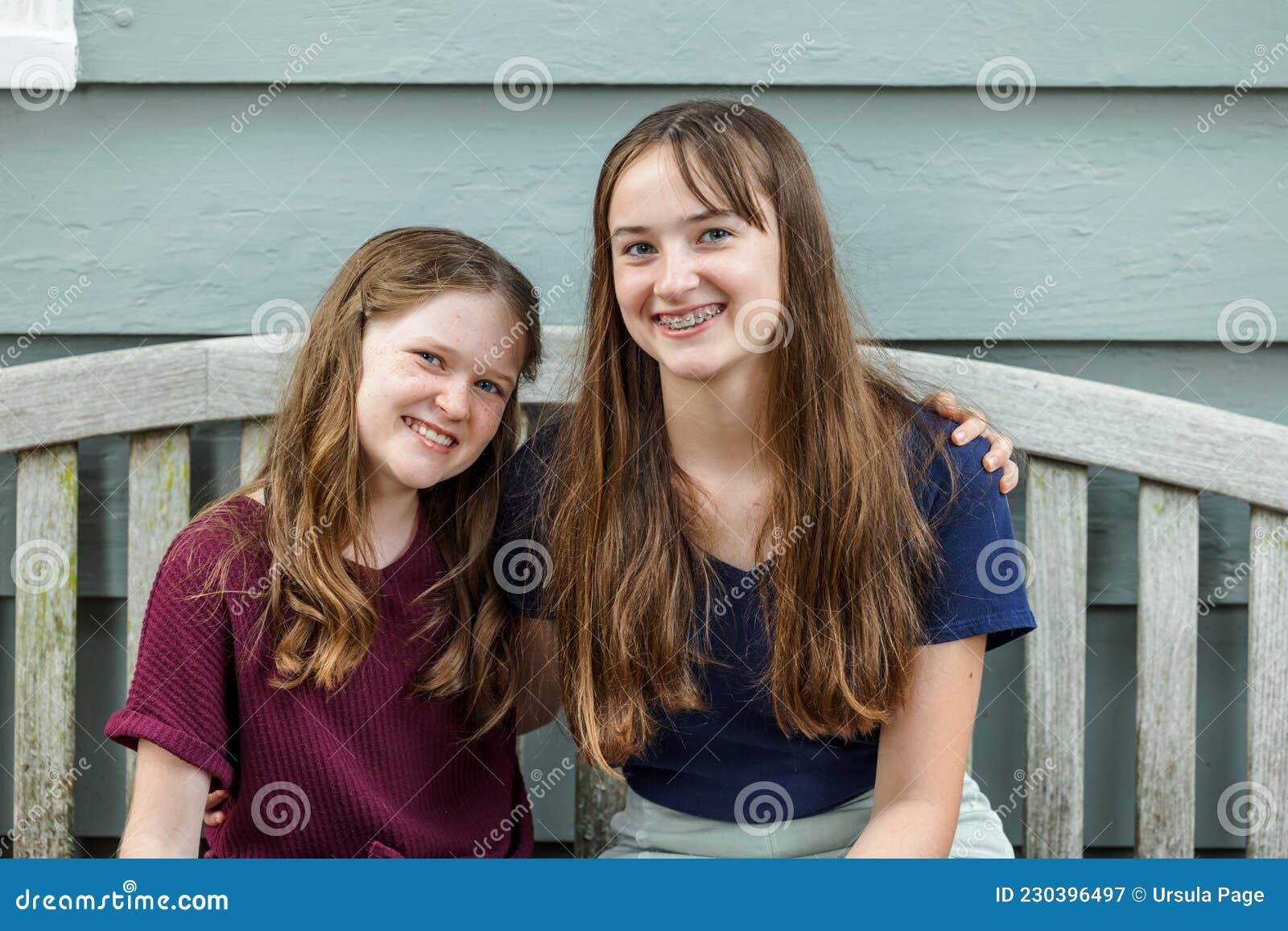 Two Sisters Embracing and Hugging on a Bench Outside Stock Image ...