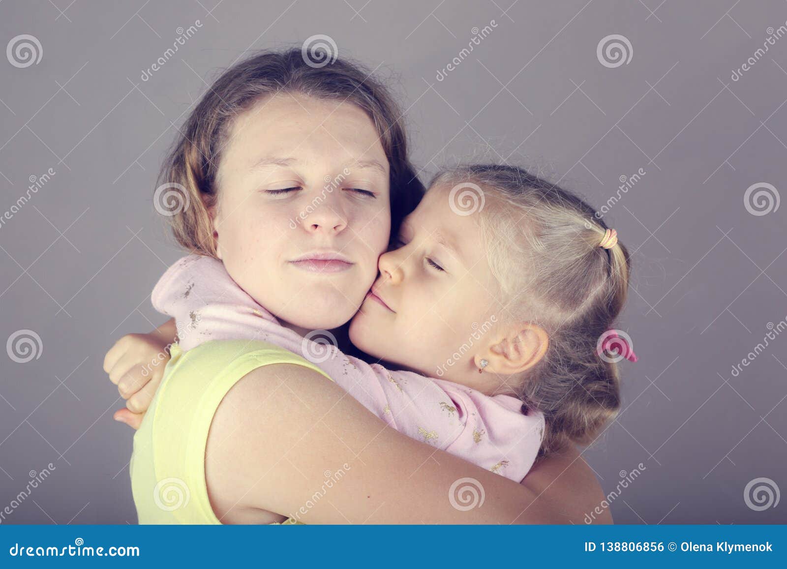 Two sisters hug each other stock photo. Image of cuddle - 138806856