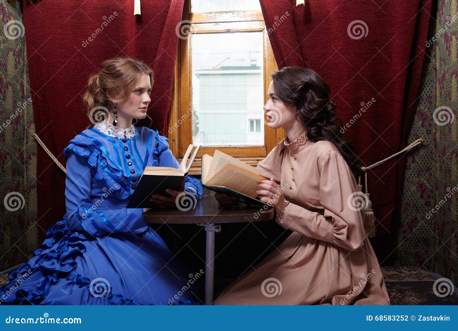 Two Sisters in Retro Dress Reading Books in Train Compartment Stock ...
