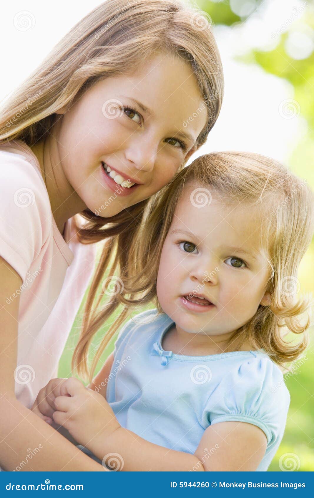 Two Sisters Sitting Outdoors Smiling Stock Photo - Image of family ...