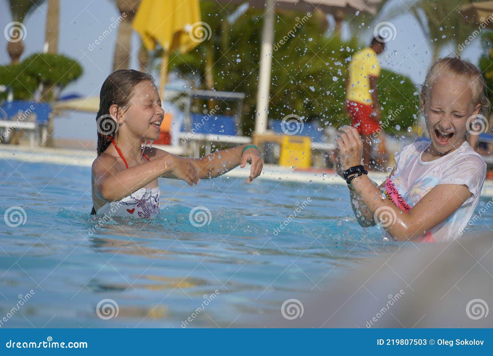 Two Sisters Splashing Around in the Pool and Laughing Stock Image ...