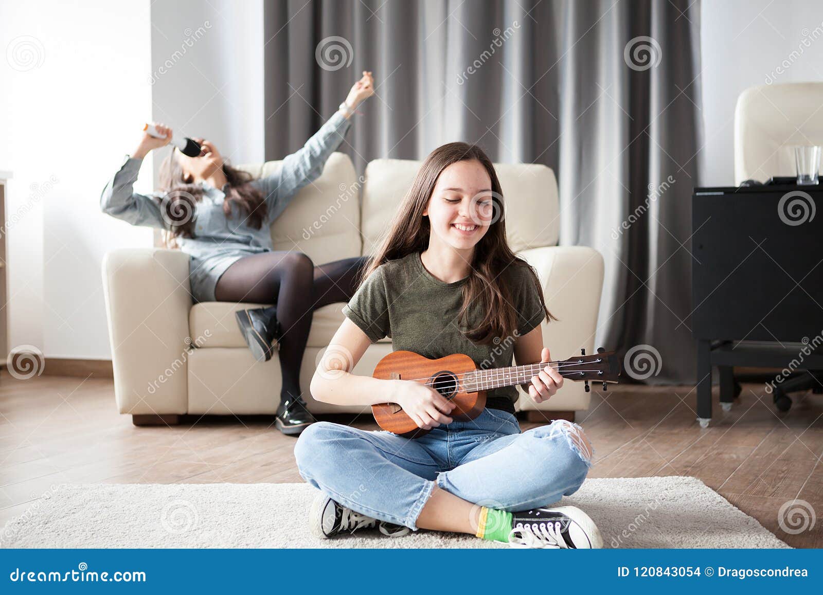 Two Sisters, the Younger One is Playing a Small Guitar in Front at the ...