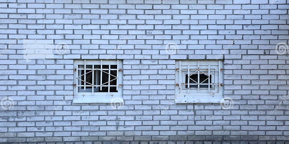 Two Small Barred Windows in a White Brick Wall Stock Photo - Image of ...