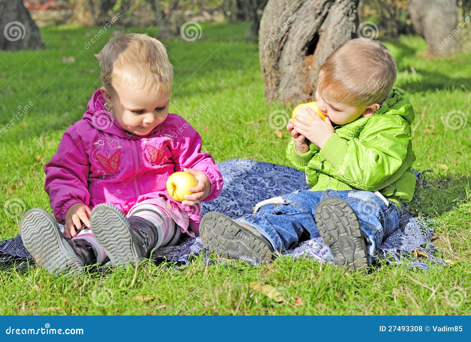 Two Small Children Sit on a Green Clearing Stock Photo - Image of child ...