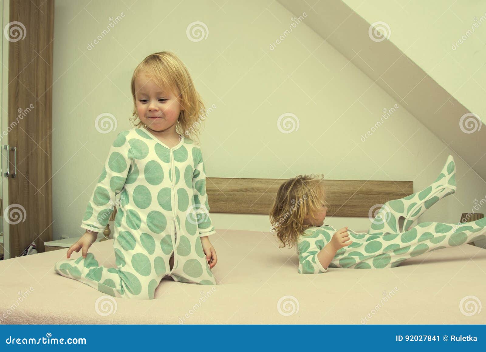 Two Small Identical Twin Sisters in Identical Pajamas, Actively Having ... Two Small Identical Twin Sisters in Identical Pajamas, Actively Having ...