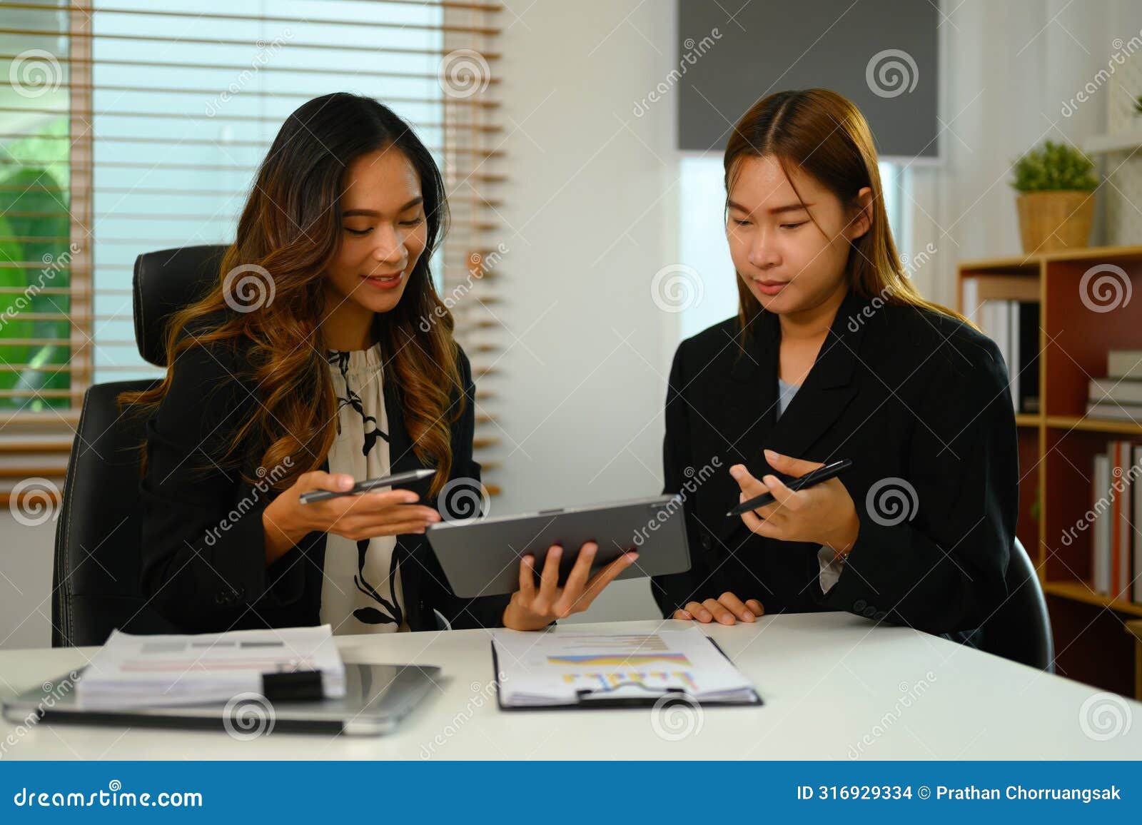 Two Smiling Business Partner Looking on Digital Tablet Screen and ...