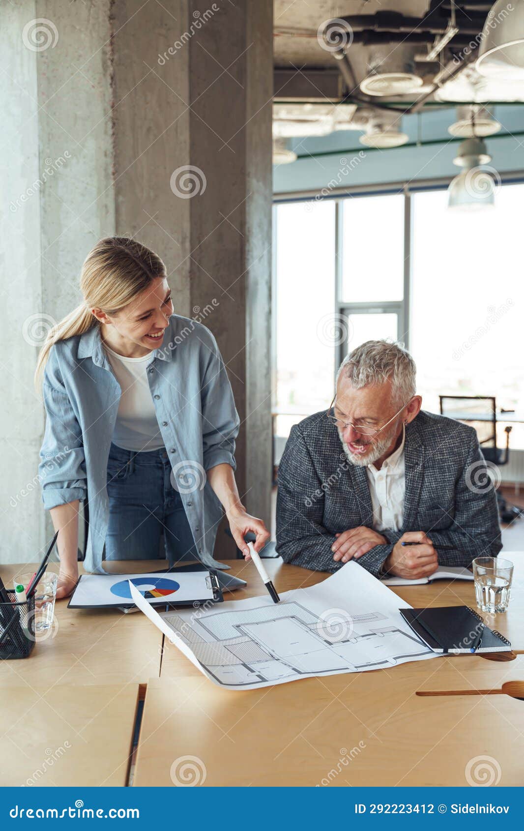 Two Smiling Design Engineers Working with Project Documents while ...