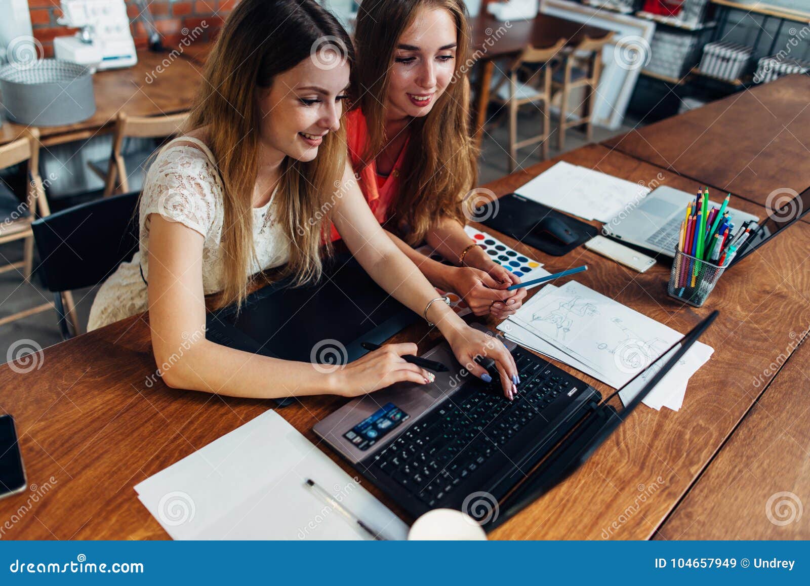 Two Smiling Female Students Doing Homework Together Using Laptop ...