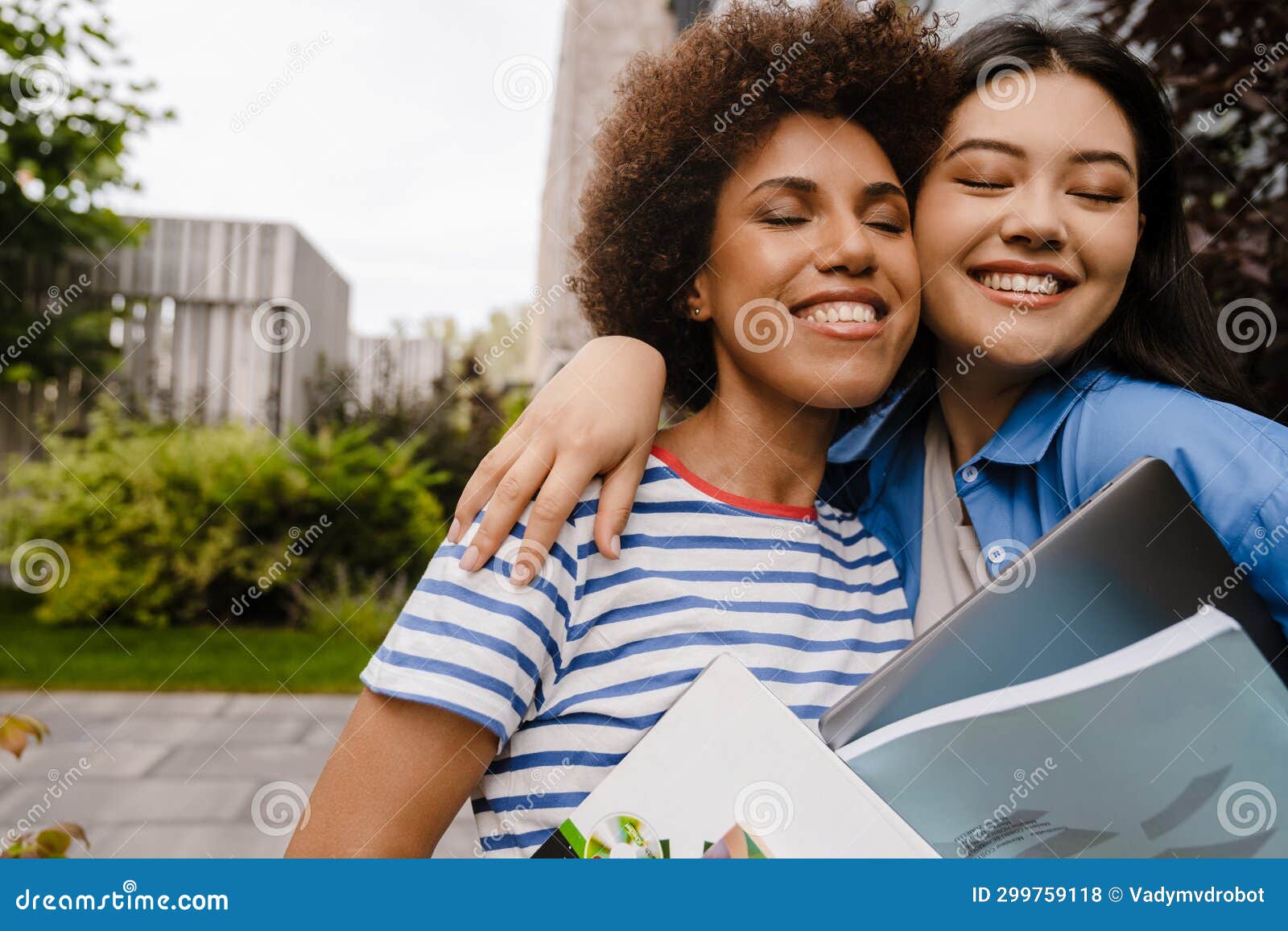 Two Smiling Female Students Hugging while Standing in Campus Stock ...