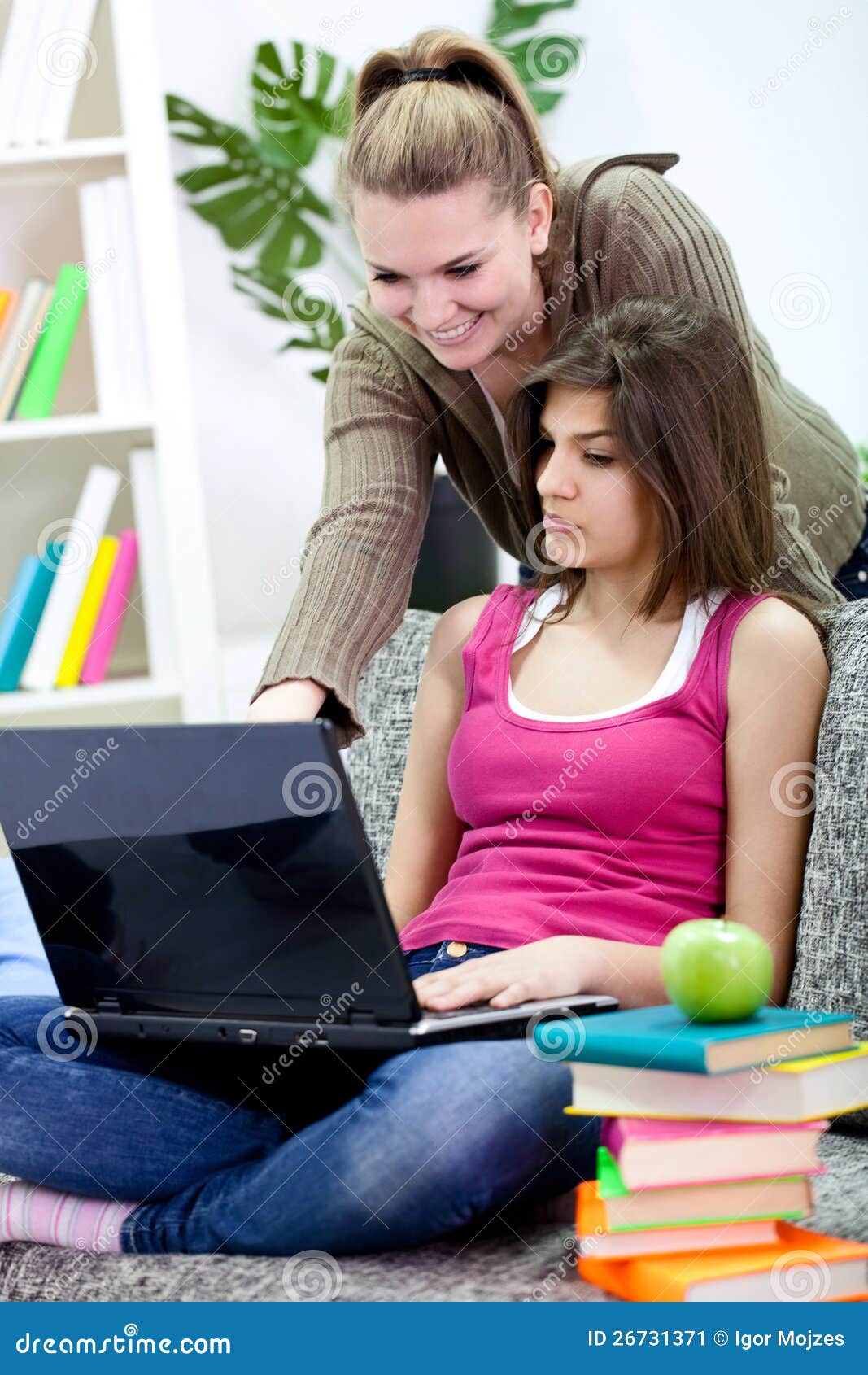 Two Smiling Girls Doing Homework Using a Laptop. Stock Image - Image of ...