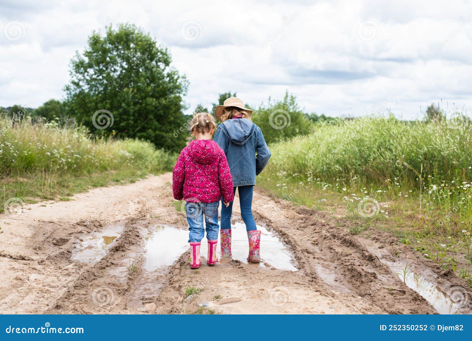 Two Girls Run through the Puddles and Play. Stock Photo - Image of ...
