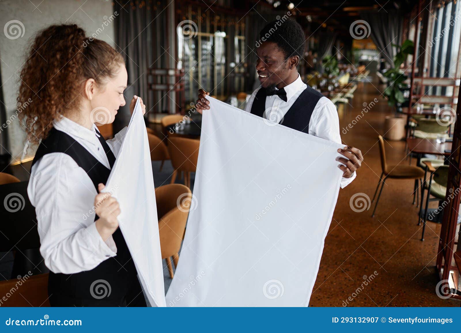 Two Smiling Servers Folding White Tablecloth Preparing Restaurant for ...
