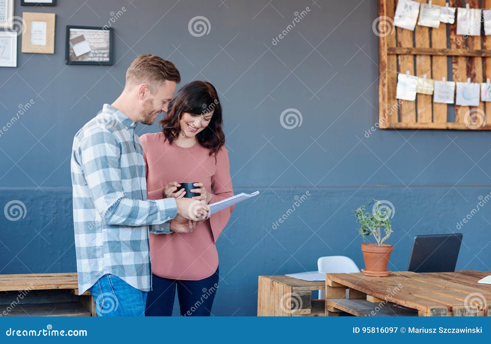 Two Smiling Work Colleagues Discussing Paperwork Together in an Office ...