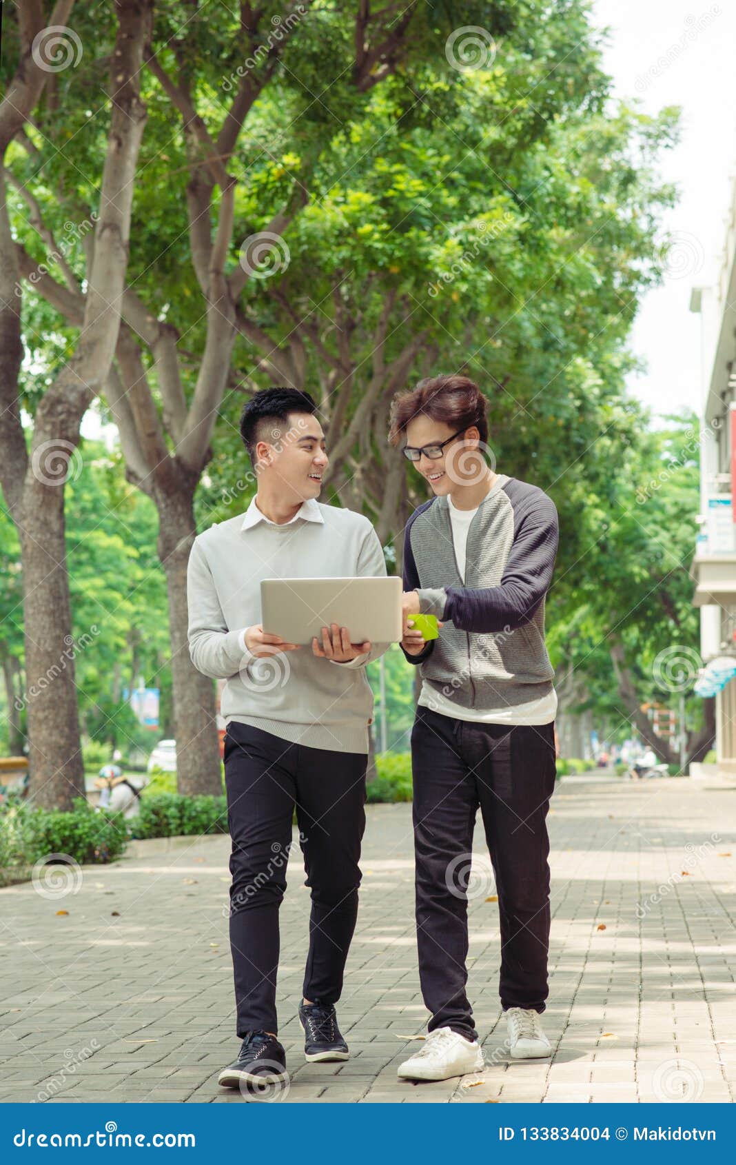 Two Smiling Young Businessmen Walking and Talking in the City Stock ...